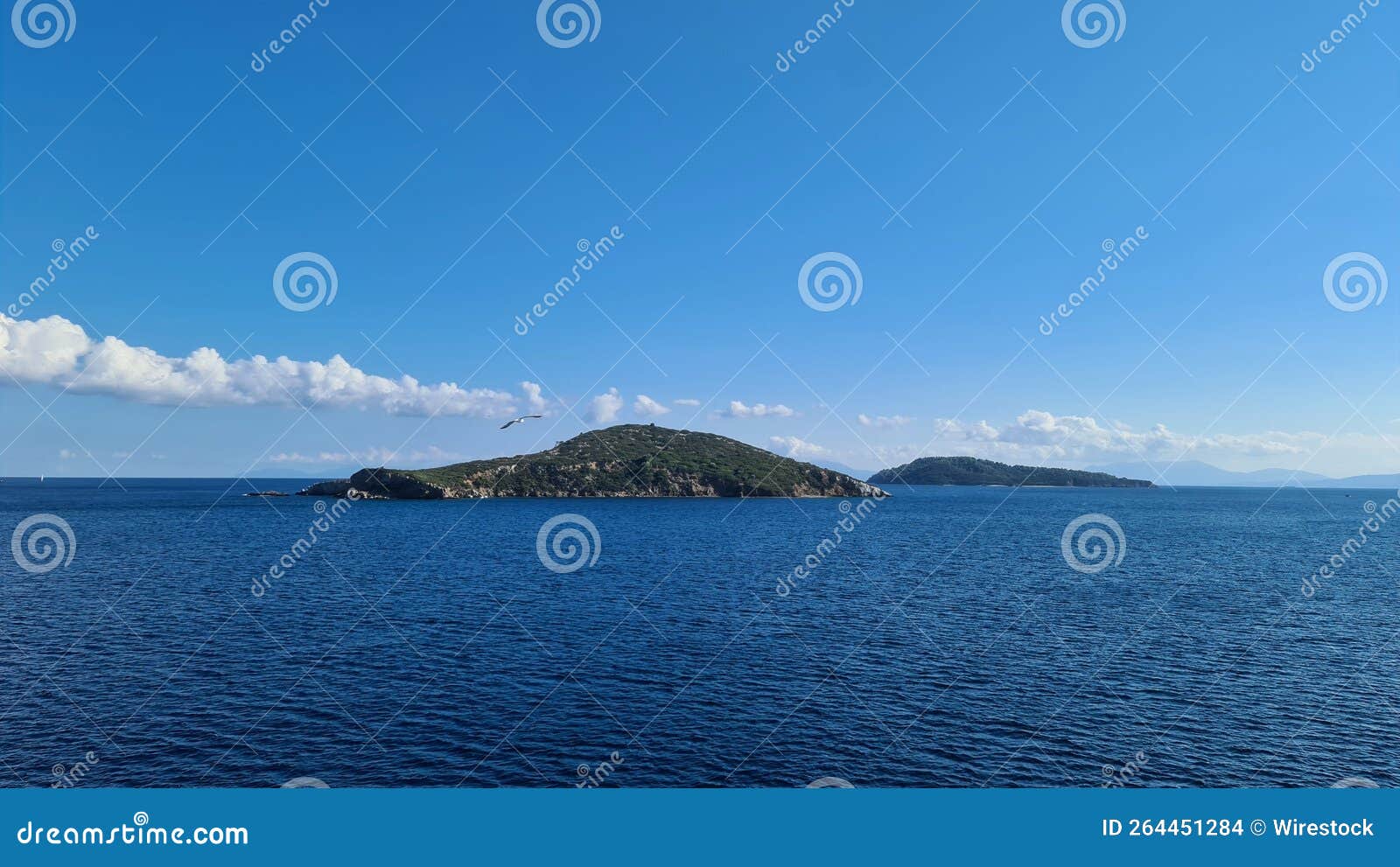 Scenic View of a Vast Blue Ocean with Green Mountains in the Background ...