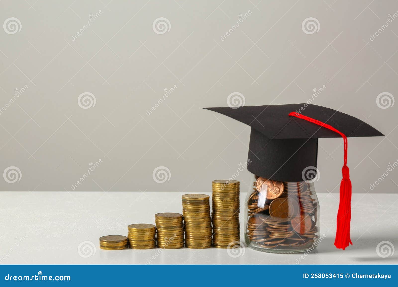 Scholarship Concept. Graduation Cap and Stacked Coins on White Table ...