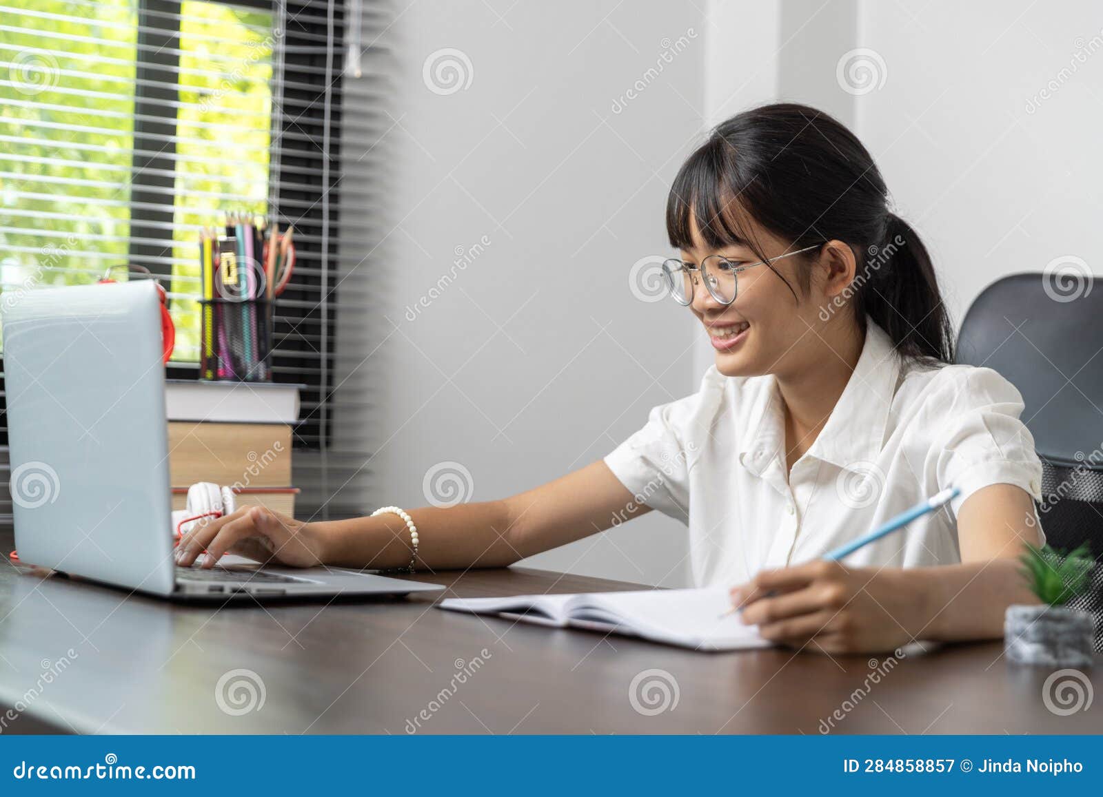 School Age Student Doing Her Homework with Digital Tablet at Home ...