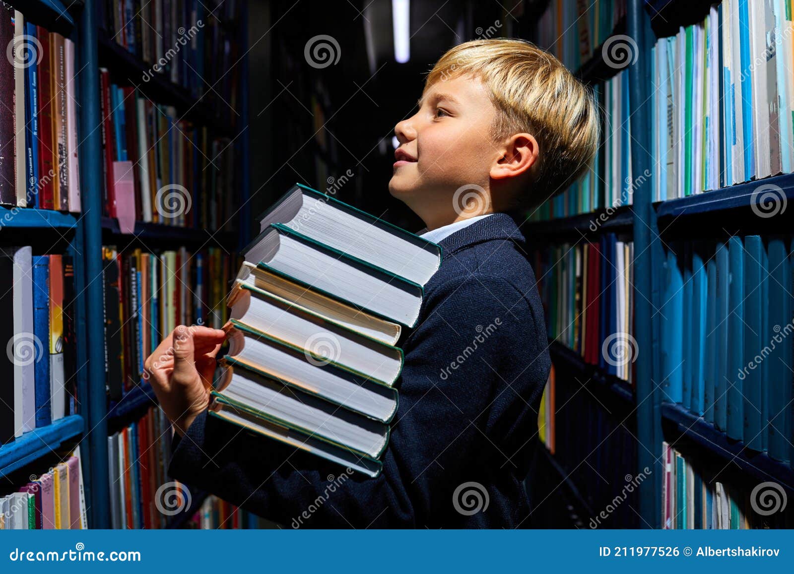 School Boy Holding Stack of Books in Library at School Stock Photo ...
