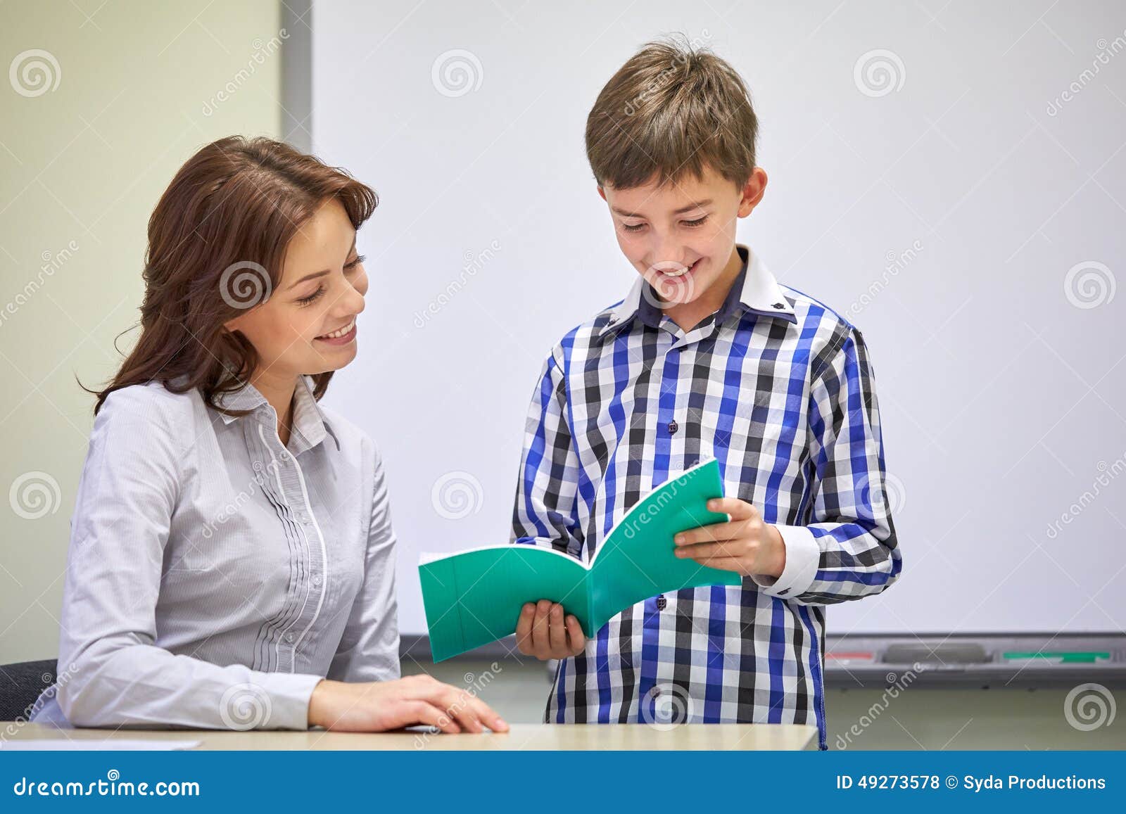 School Boy with Notebook and Teacher in Classroom Stock Photo - Image ...