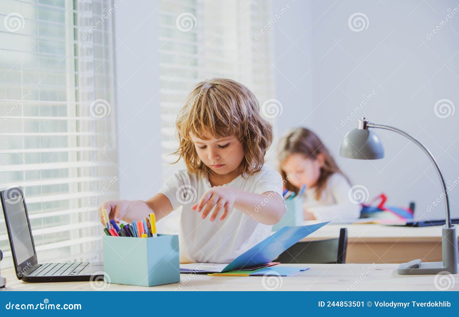 School Boy Sitting at the Table, Writing Homework or Preparing for the ...
