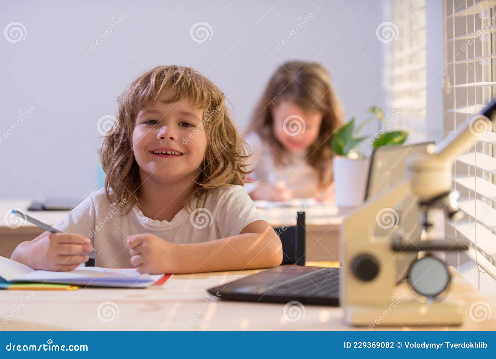 School Boy Sitting at the Table, Writing Homework or Preparing for the ...