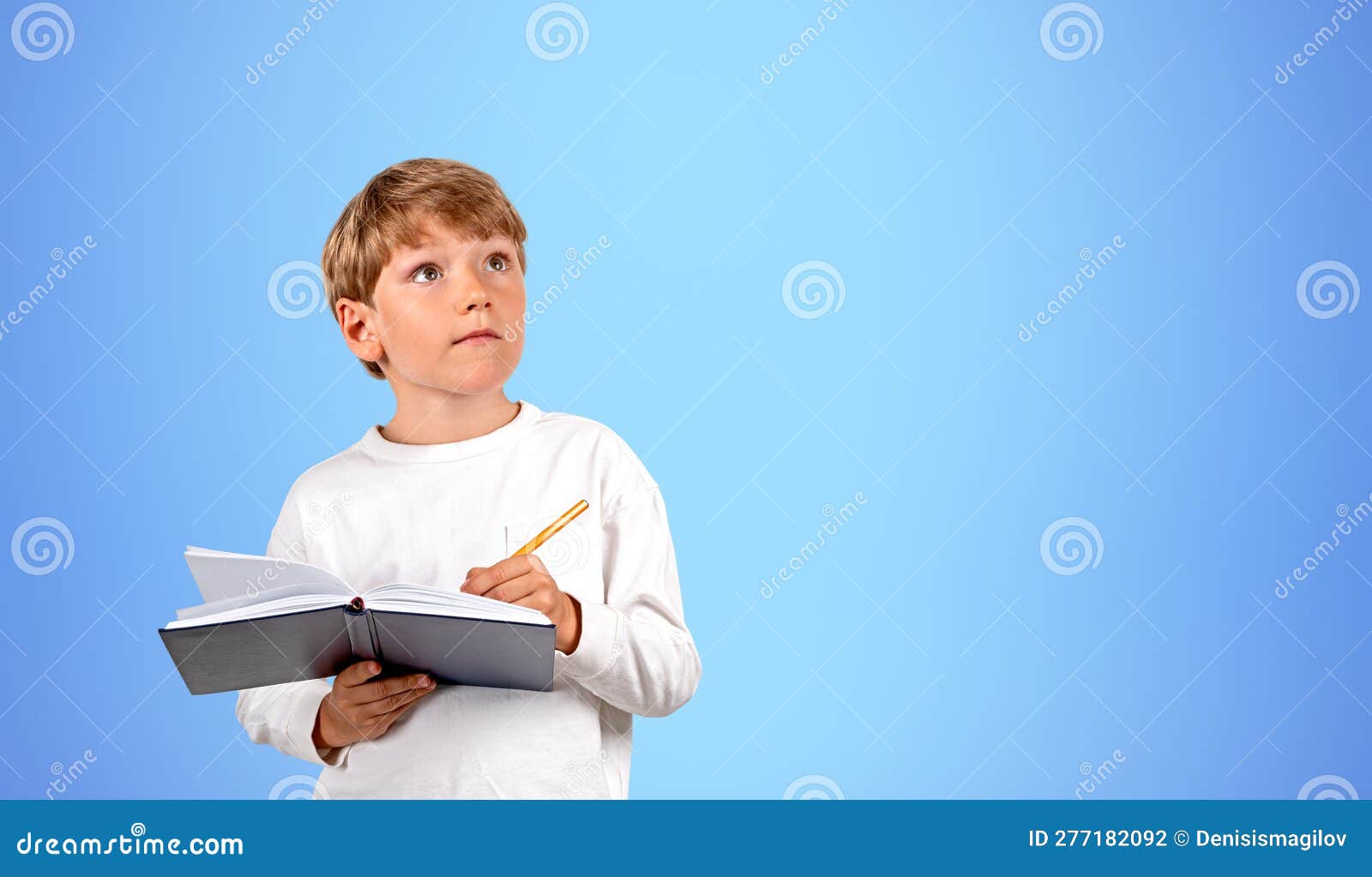 School Boy Taking Notes, Looking Up Portrait on Empty Blue Backg Stock ...
