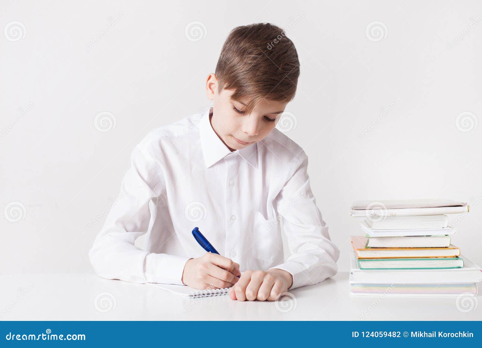 School Boy Writes in Notebook at the Table Stock Photo - Image of ...