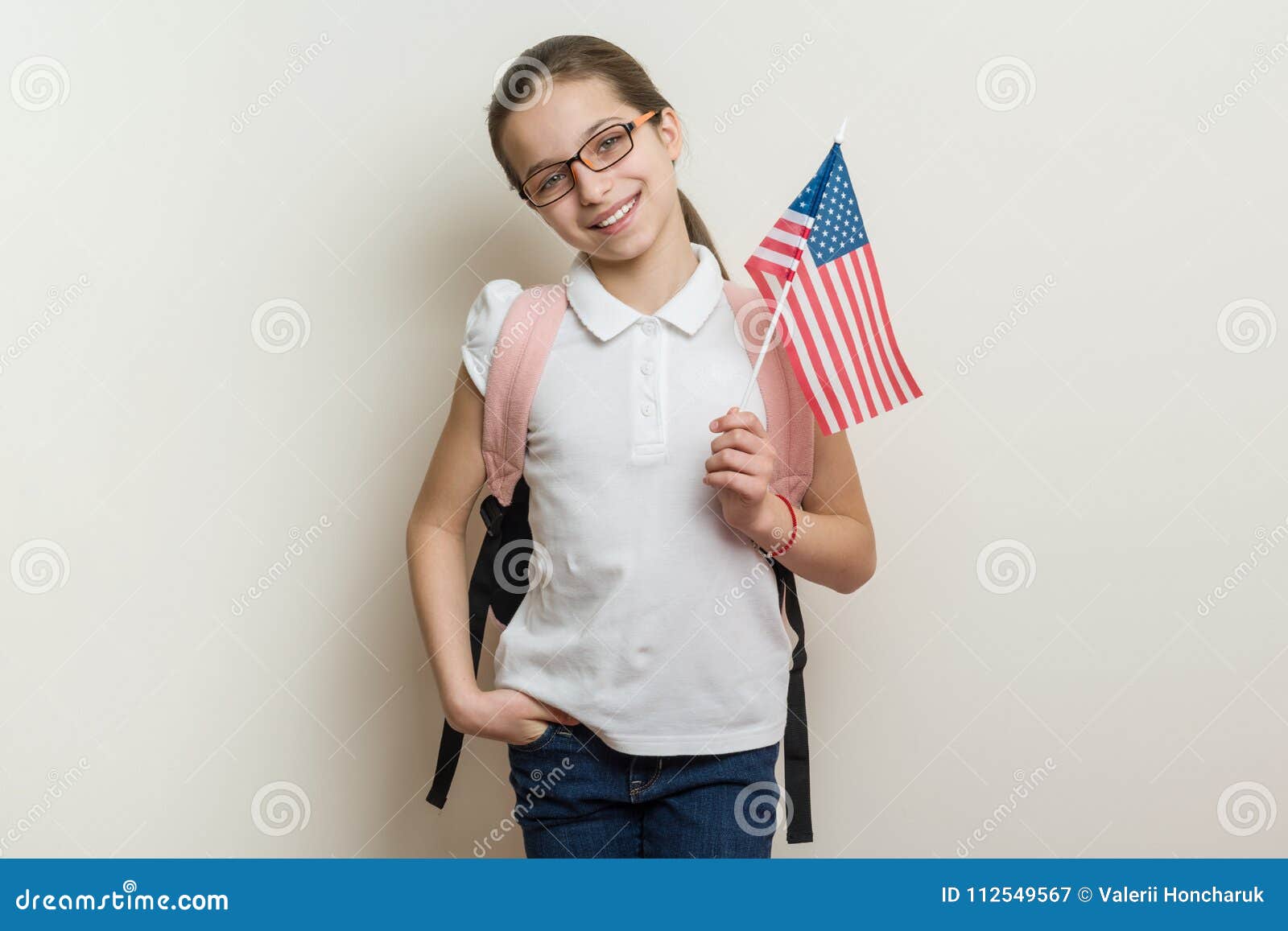 School Child with a Backpack Holds the US Flag, Background Bright Wall ...
