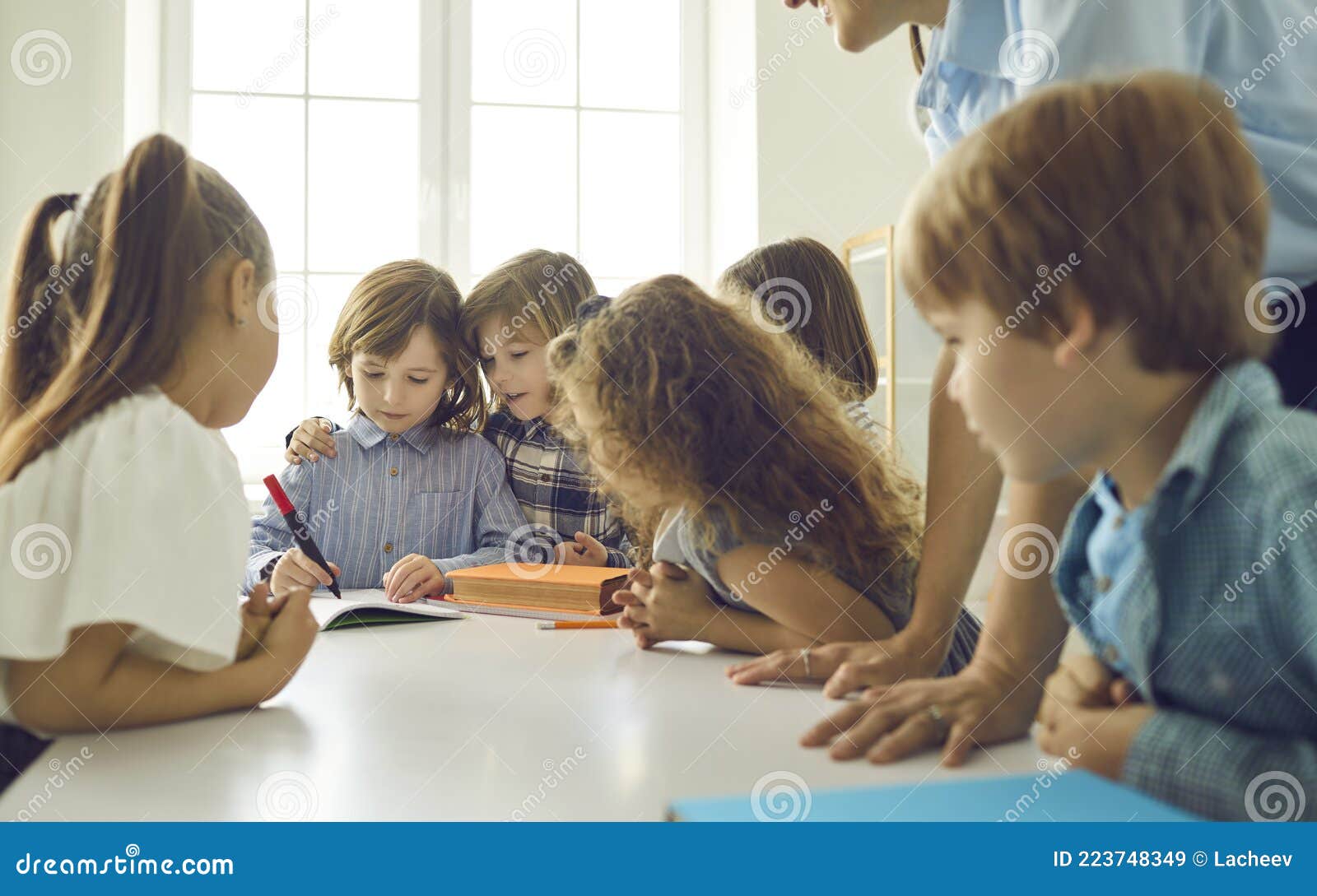 School Children Learning, Writing, Communicating and Helping Each Other ...