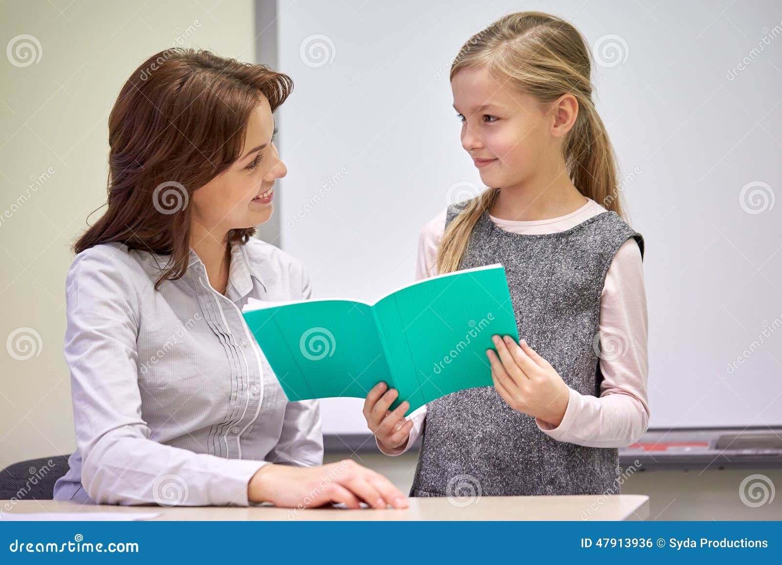 School Girl with Notebook and Teacher in Classroom Stock Photo - Image ...