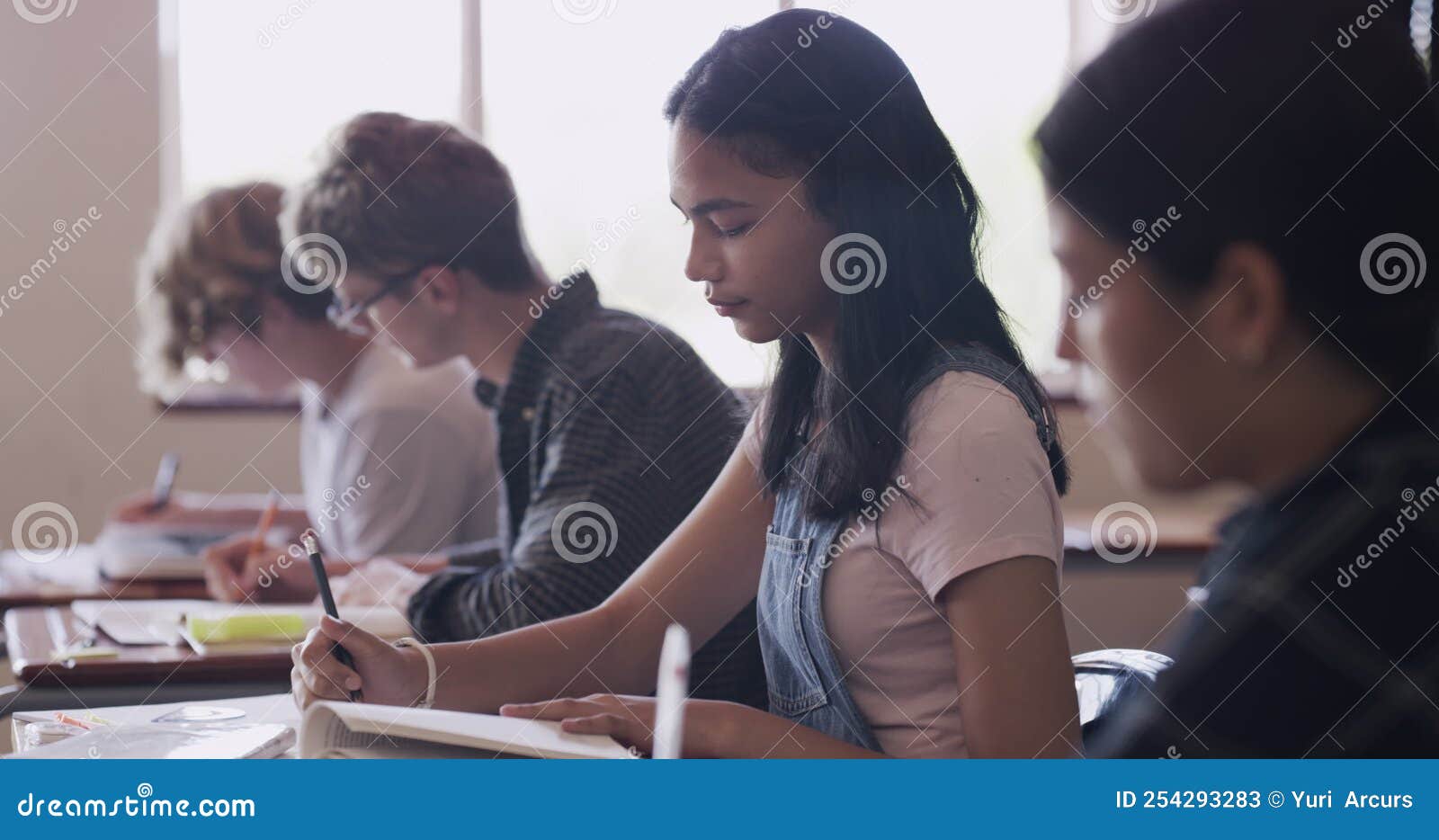 School Girl Writing in Book in Classroom, Student Learning for ...