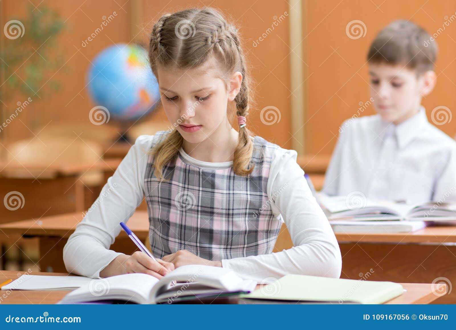 School Girl Writing in Notebook in Classroom Stock Photo - Image of ...