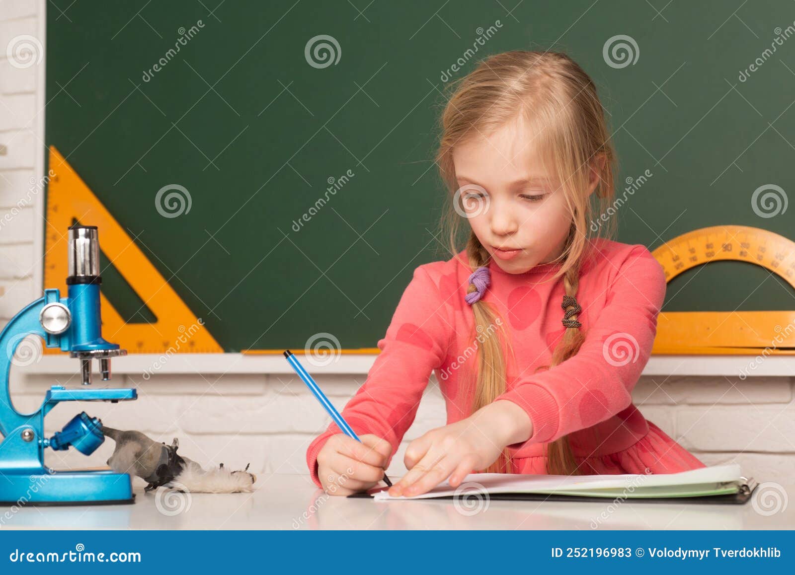 School Girl Writing in Notepad and Doing School Homework. Thinking ...