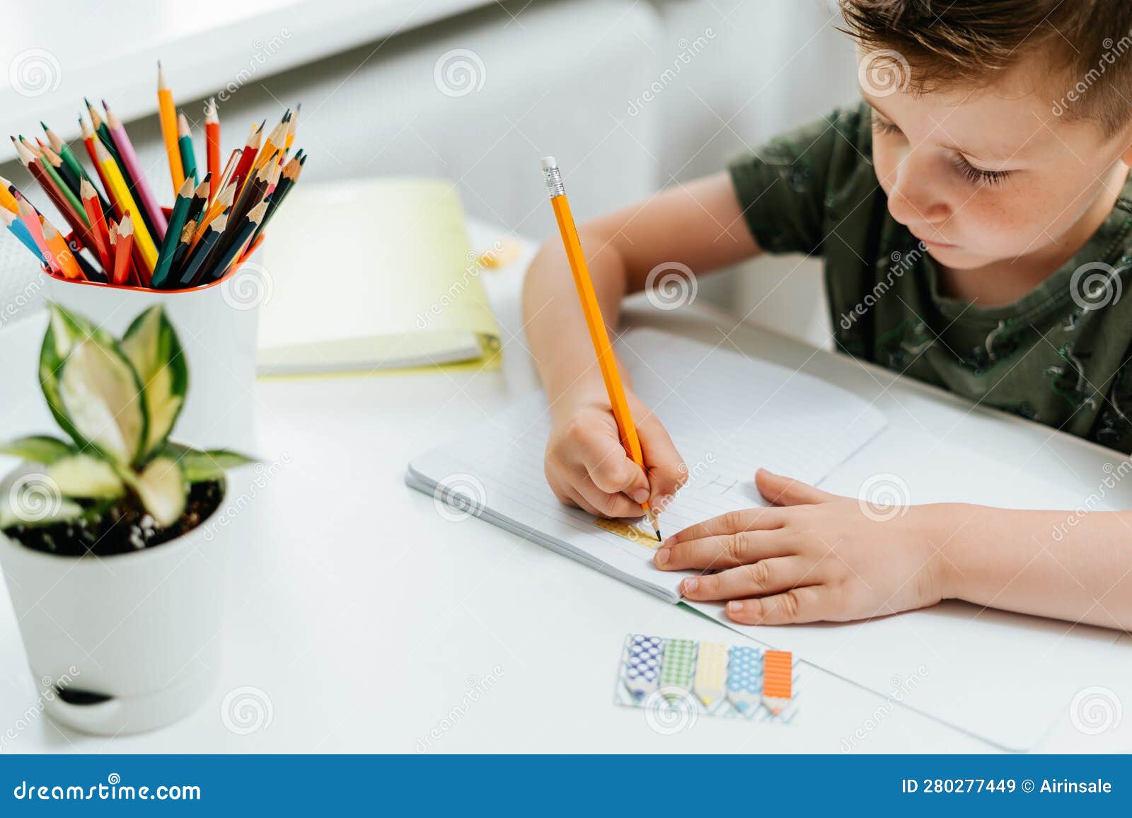 School Kid Boy Studying at Home with Book, Draw in Notepad and Doing ...