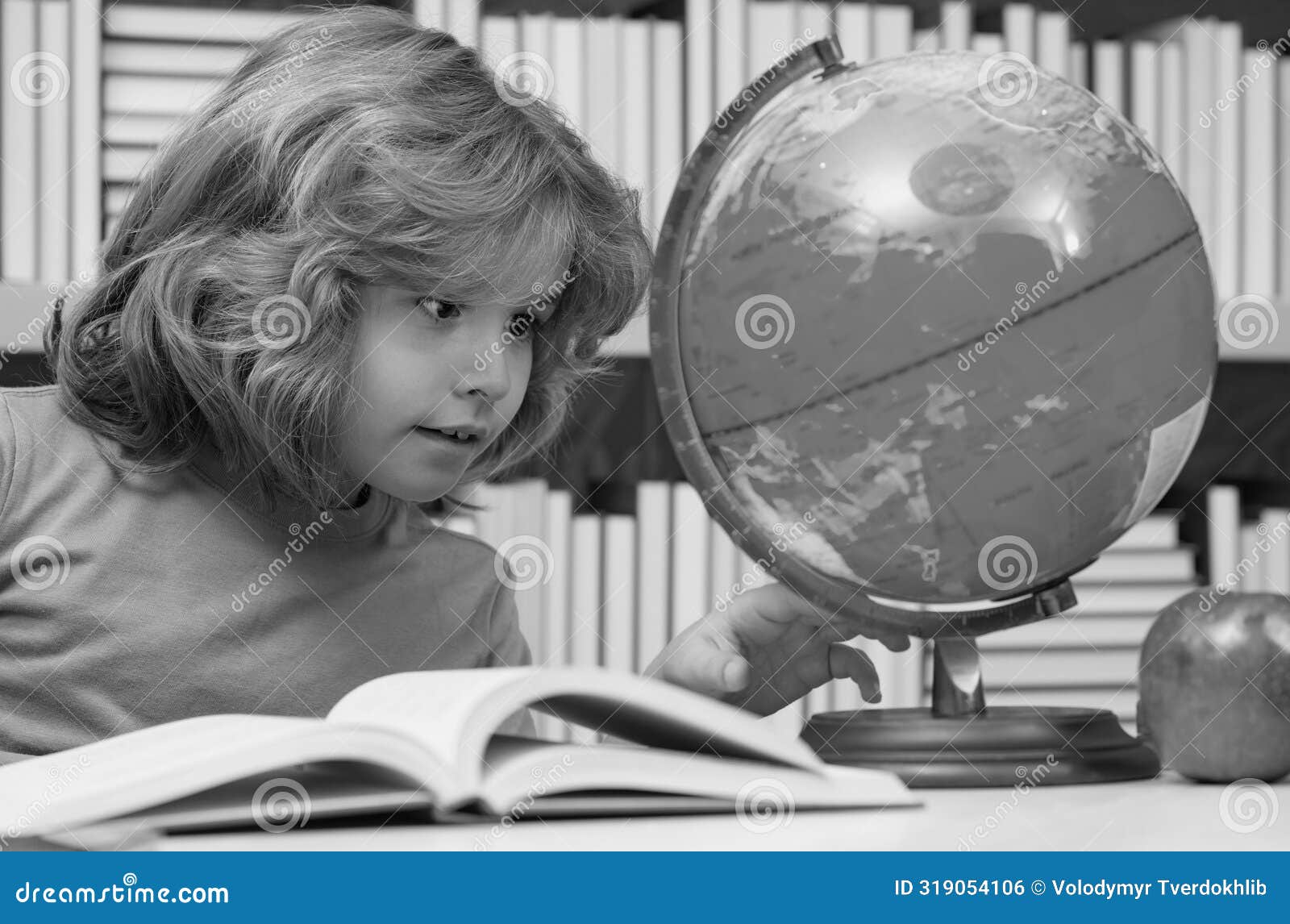 School Kid Looking at Globe in Library at the Elementary School. Child ...