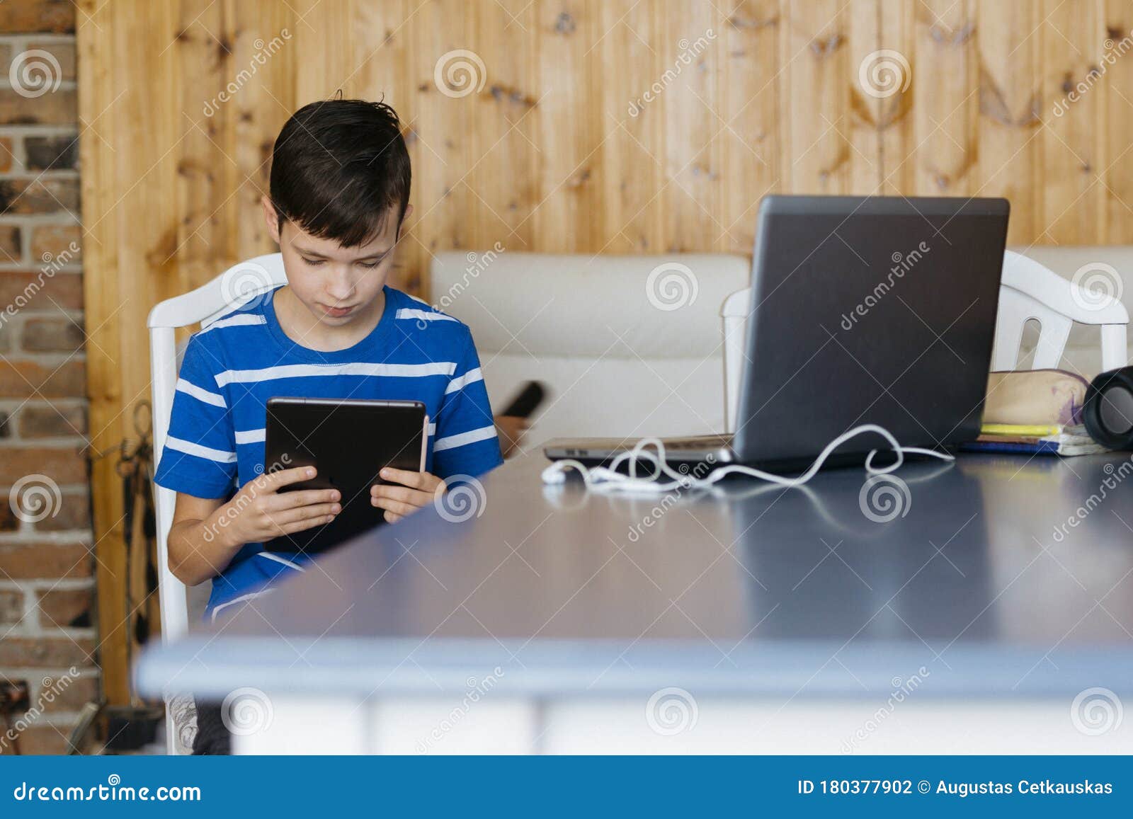 School Kid Using Laptop while Doing Schoolwork at Home. Homeschooling ...