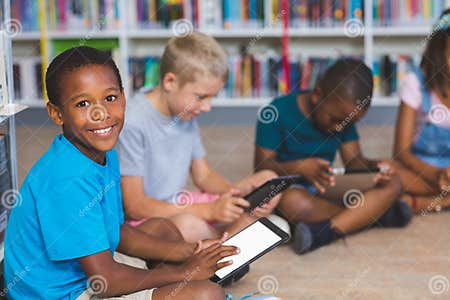 School Kids Sitting on Floor Using Digital Tablet in Library Stock ...