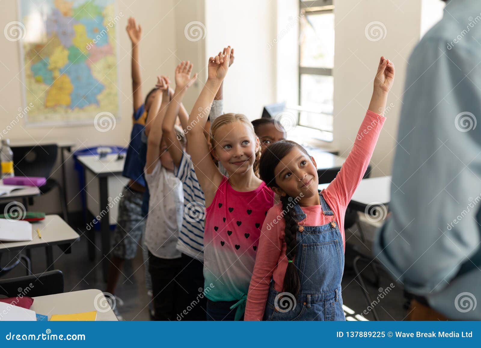 School Kids Standing in Row and Raising Hand in Classroom Stock Image ...