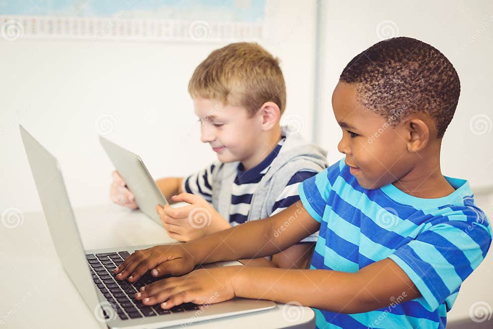 School Kids Using a Laptop and Digital Tablet in Classroom Stock Photo ...