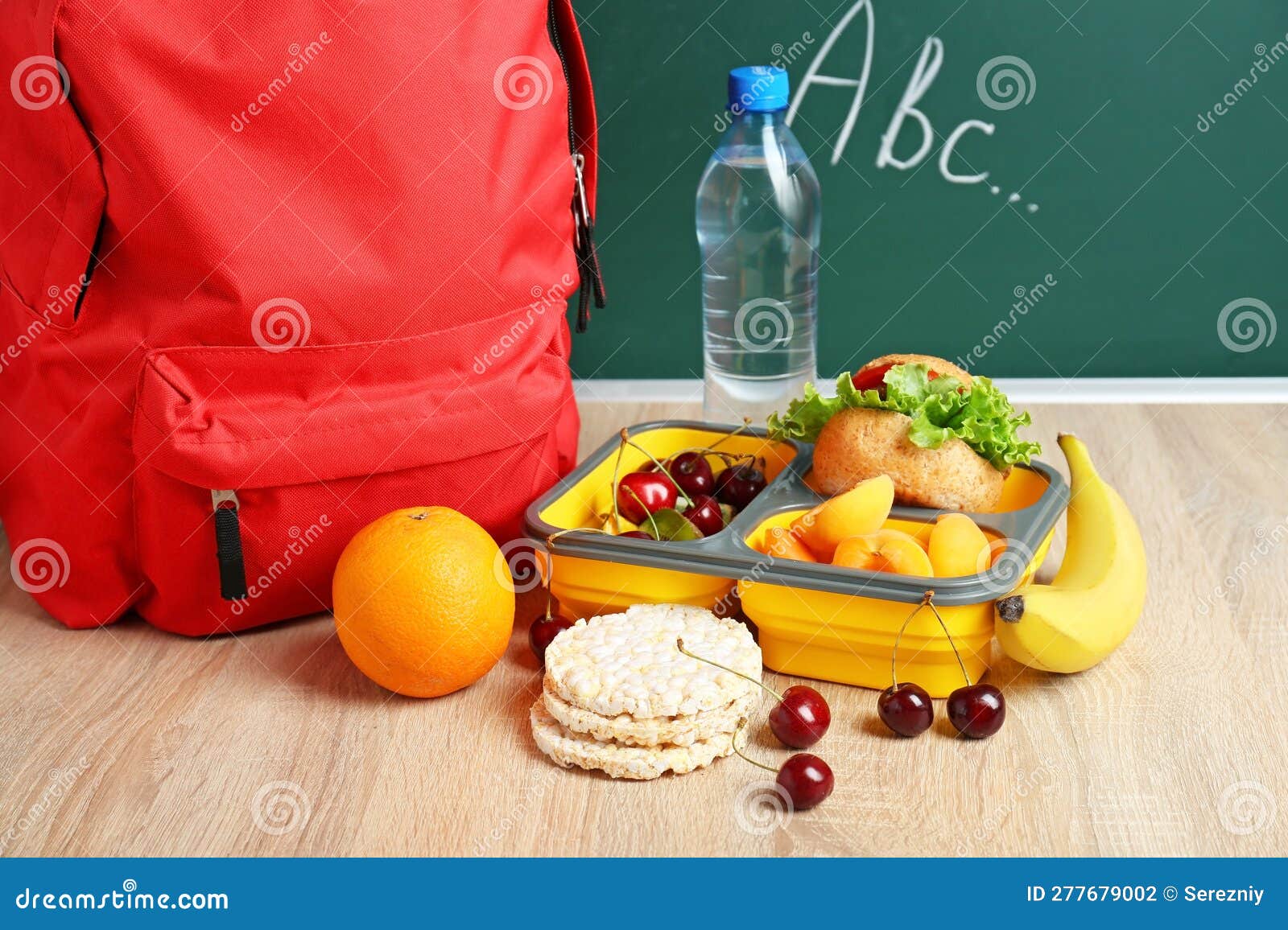 School Lunch Box with Tasty Food and Backpack on Table in Classroom ...