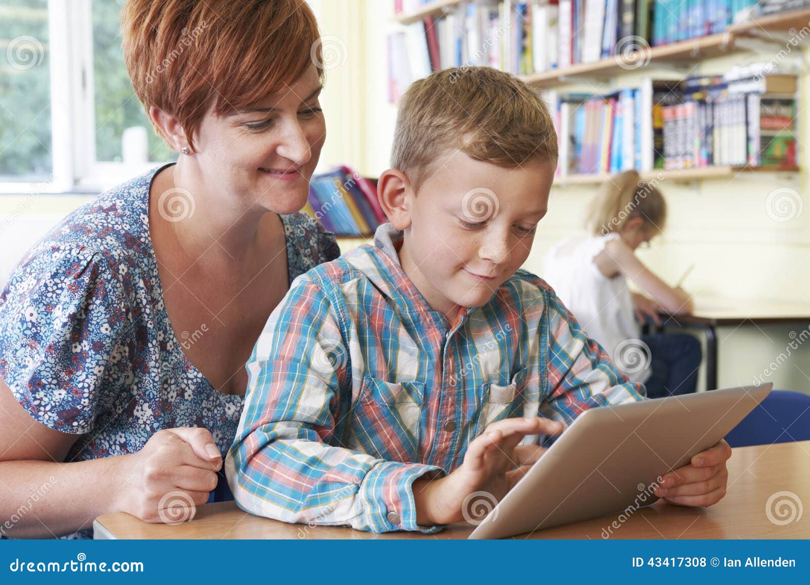 School Pupil with Teacher Using Digital Tablet in Classroom Stock Photo ...