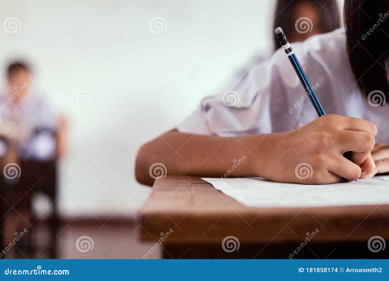 School Student is Taking Exam and Writing Answer in Classroom for ...