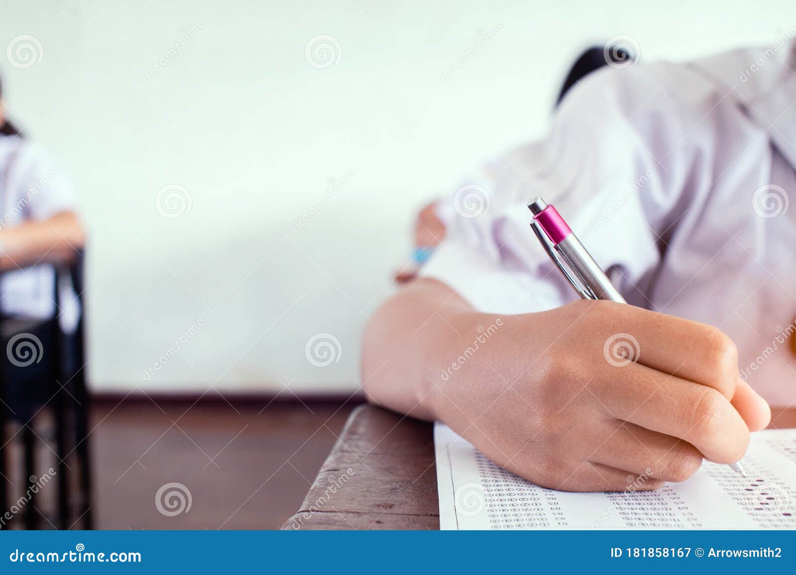 School Student is Taking Exam and Writing Answer in Classroom for ...