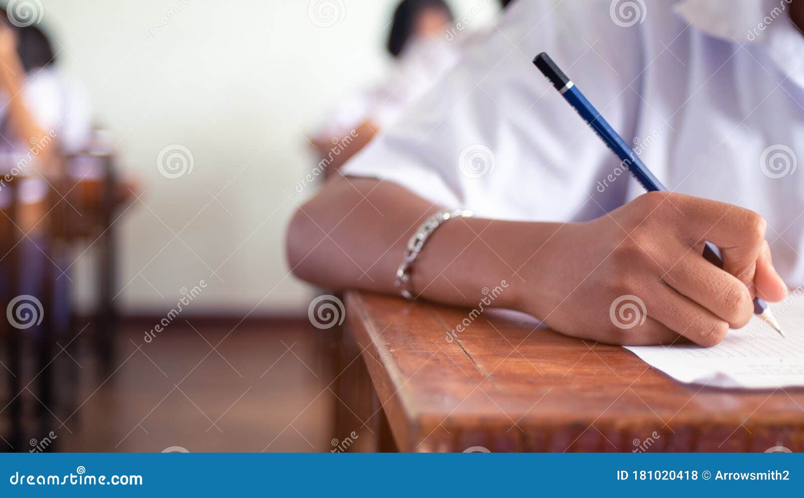 School Student is Taking Exam and Writing Answer in Classroom for ...