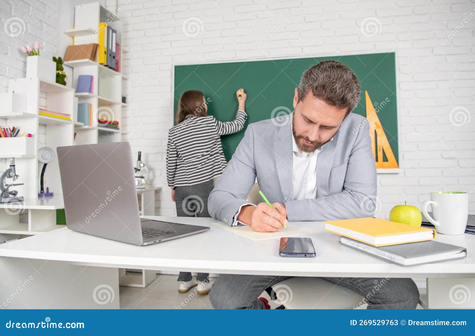 School Teacher in Classroom with Selective Focus of Kid at Blackboard ...