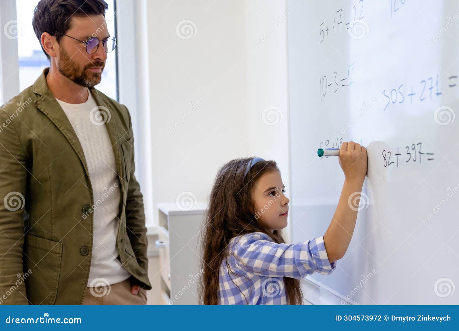 School Teacher Helping Pupil Writing on White Board Solving Math ...
