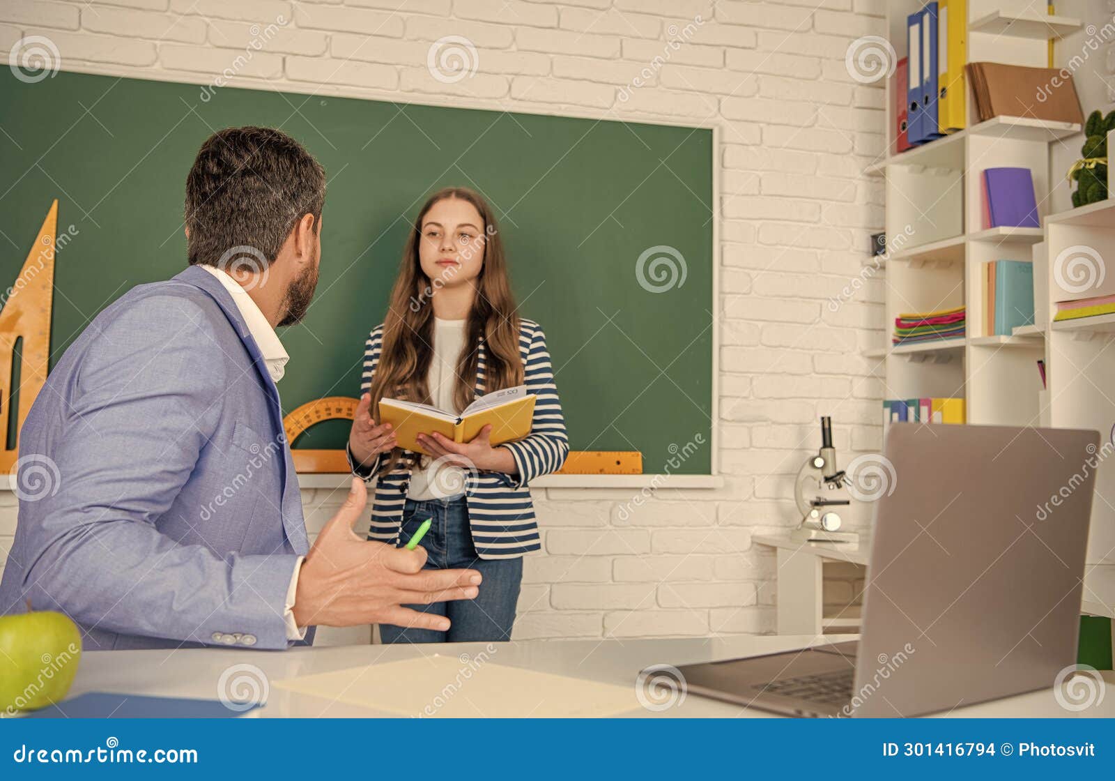 School Teacher with Selective Focus of Girl at Blackboard Stock Photo ...
