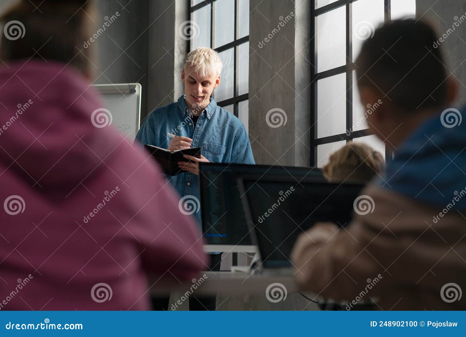 School Teacher Standing in Front of Pupils and Writing Notes in ...