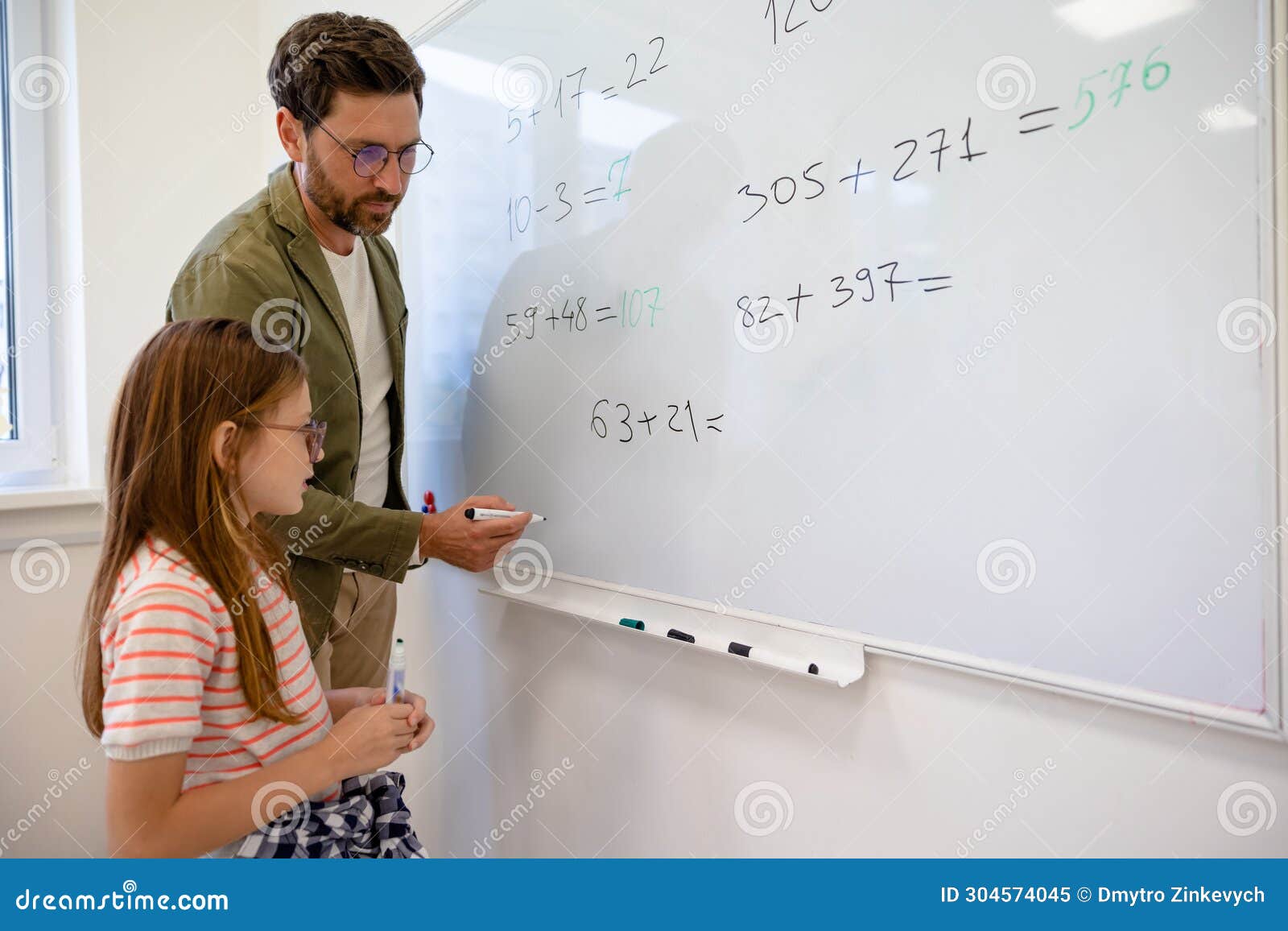 School Teacher Watching Pupil Writing on White Board in Classroom ...