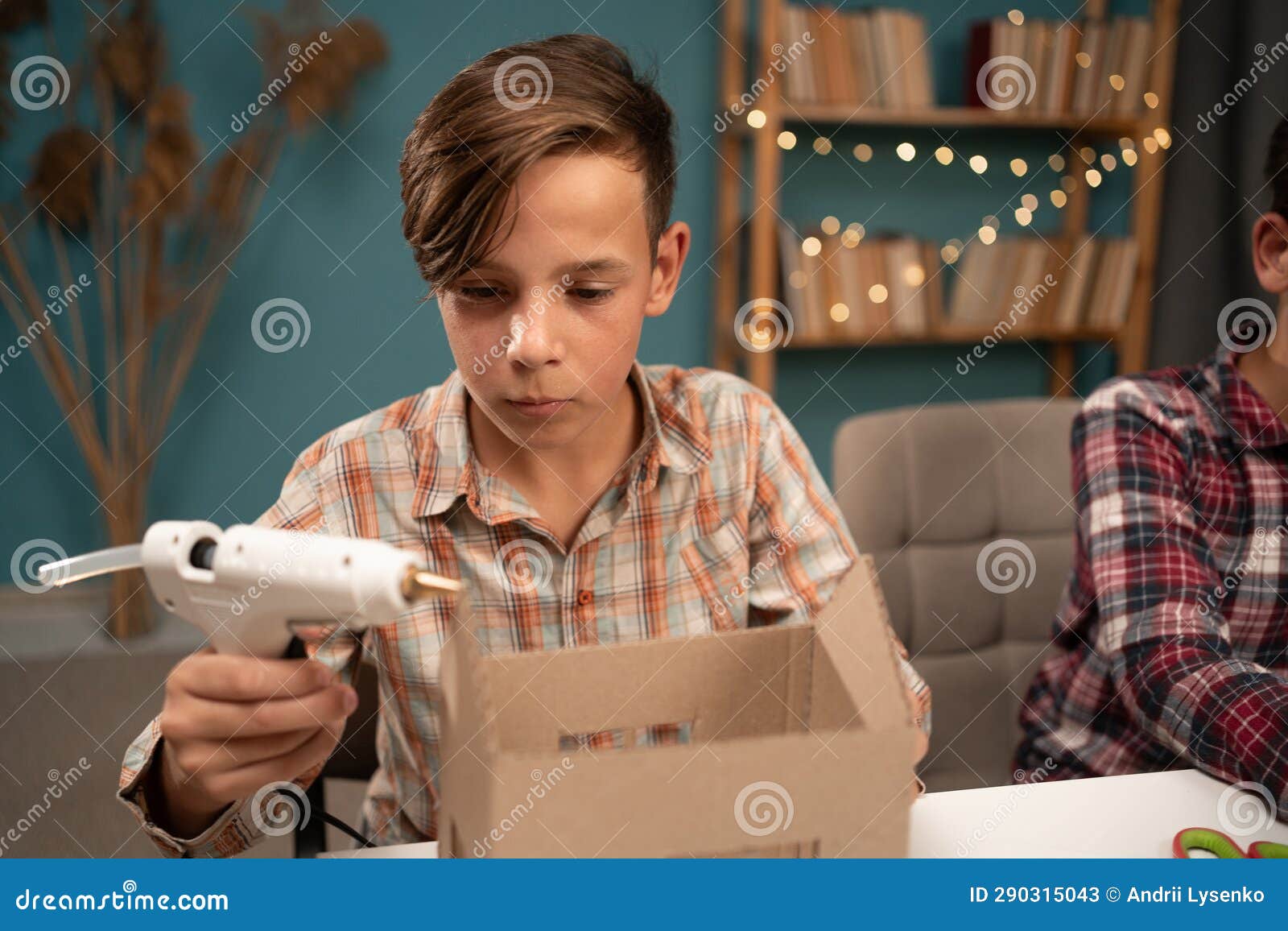 A Schoolboy Doing Creative Handcraft from a Carton Board for School ...