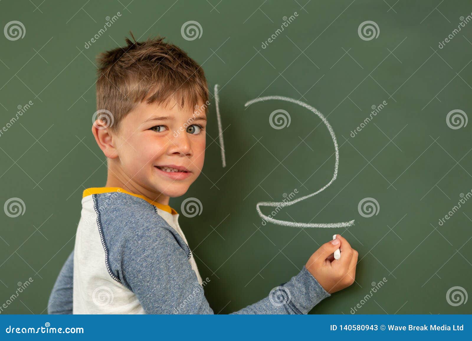 Schoolboy Doing Math on Green Chalkboard in a Classroom Stock Image ...
