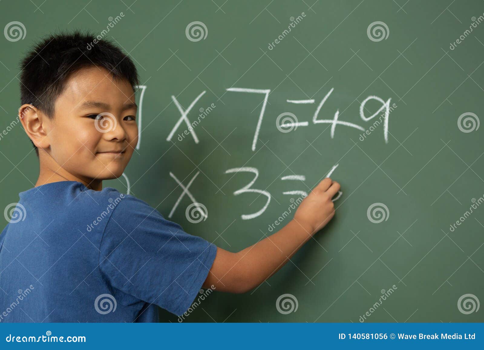 Schoolboy Doing Math on Greenboard in a Classroom Stock Photo - Image ...