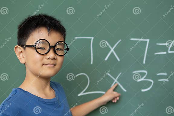 Schoolboy Doing Math on Greenboard in a Classroom Stock Photo - Image ...