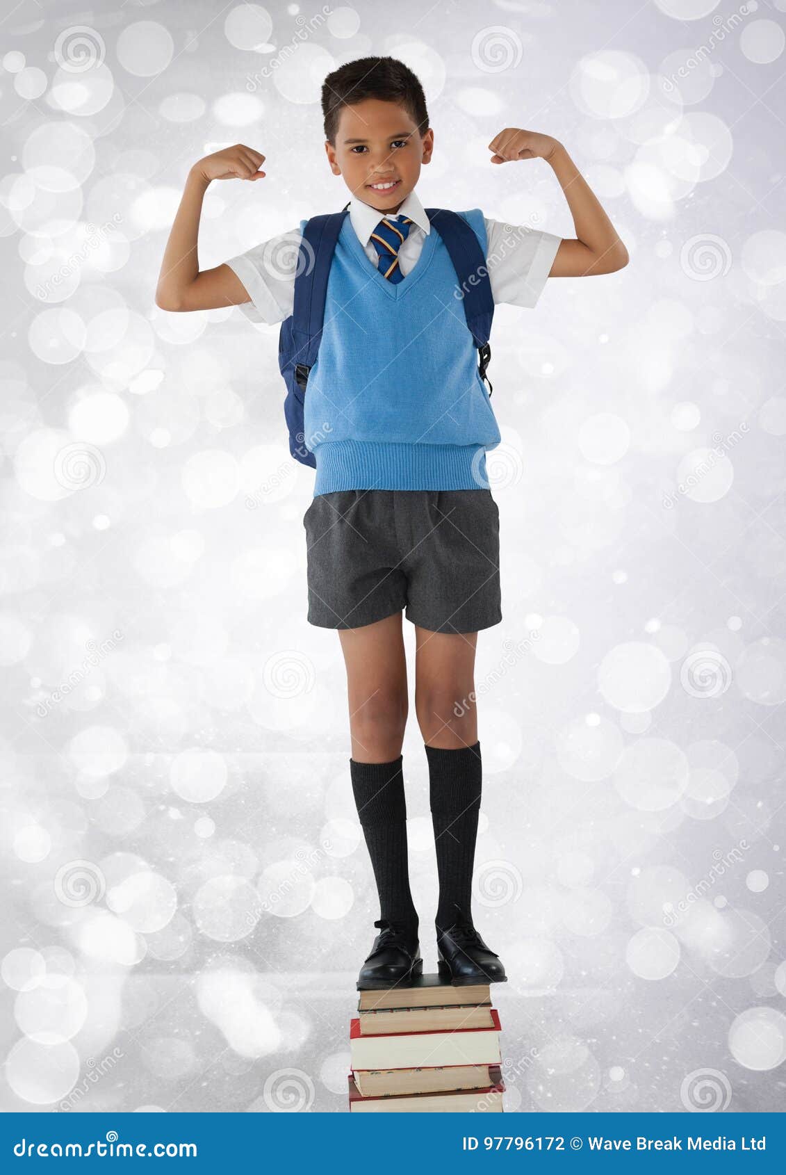 Schoolboy Flexing Strong Arms while Standing on Books and Bokeh Bright ...