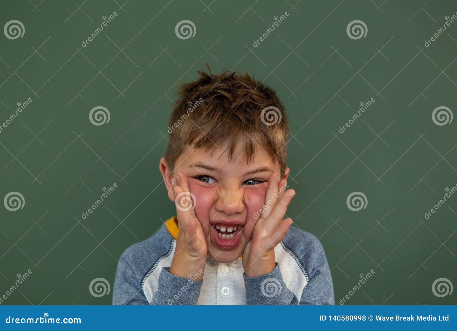 Schoolboy with Hands on Face and Surprised Against Greenboard in a ...