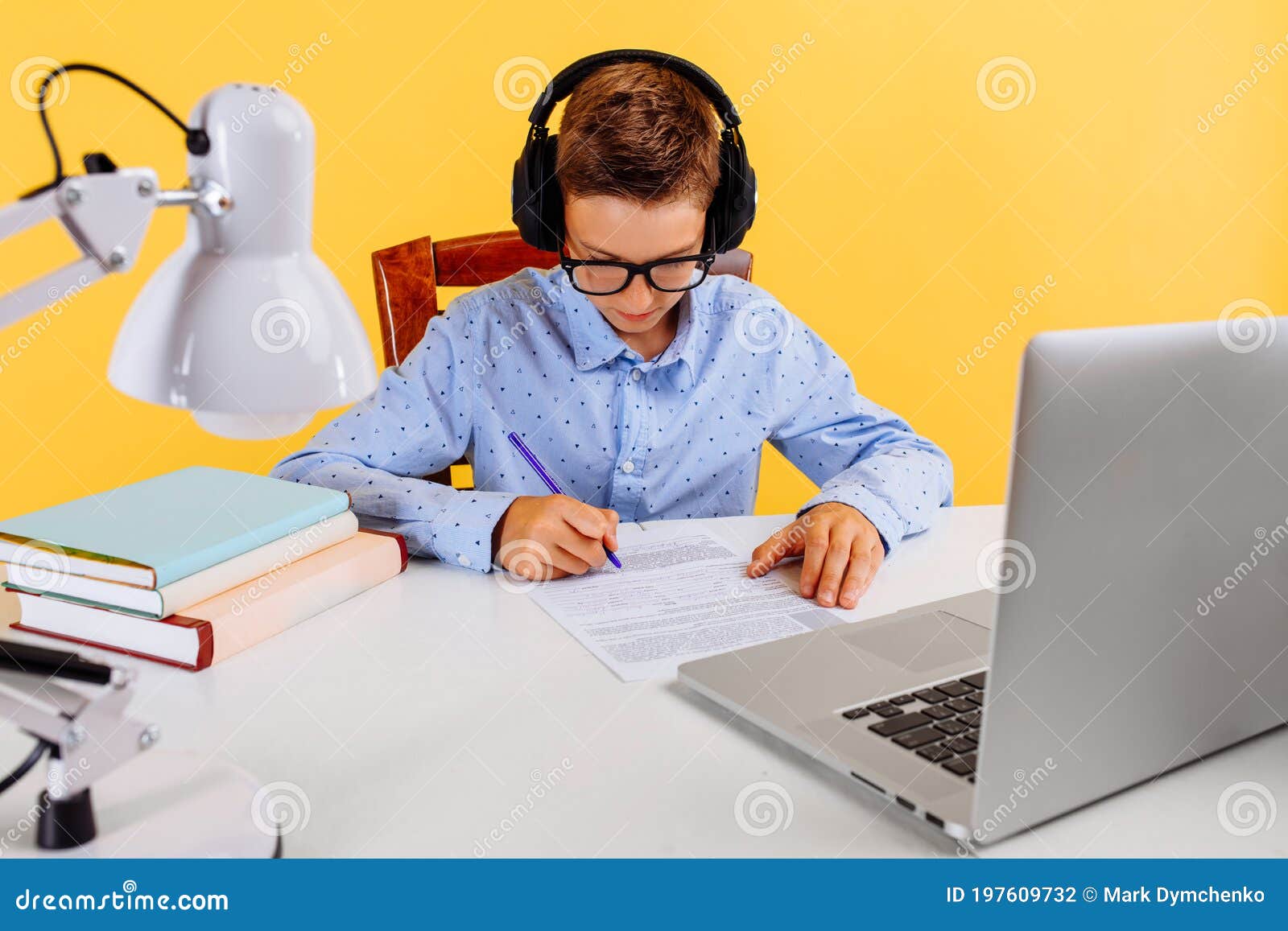 Schoolboy in Headphones, Doing Homework Using a Laptop Computer ...