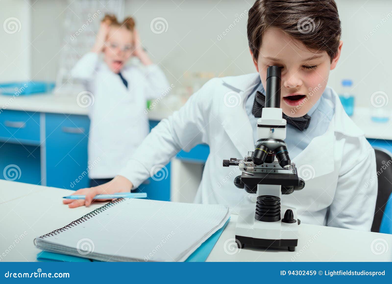 Schoolboy with Microscope and Copybook in Science Laboratory Stock ...