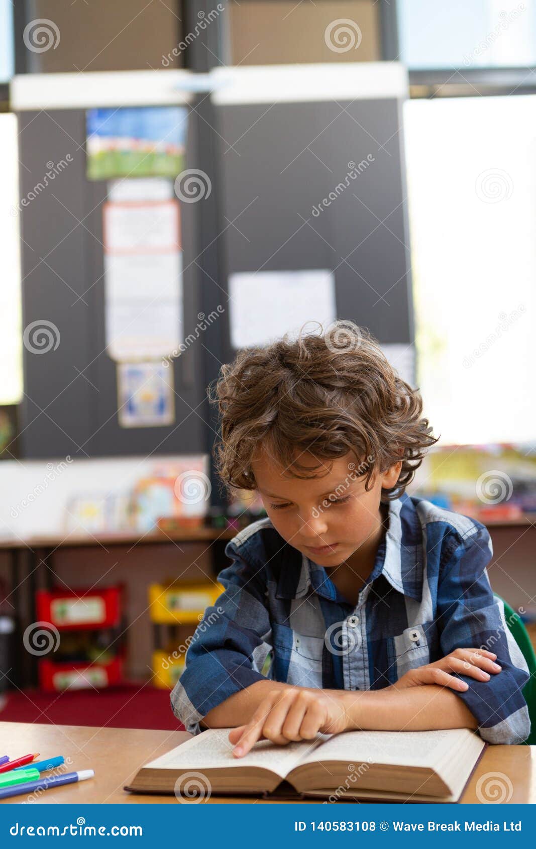Schoolboy Reading a Book in the Classroom Stock Photo - Image of ...