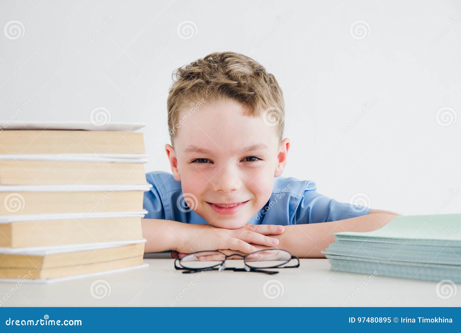 Schoolboy in School Uniform Sitting at a Desk with Textbooks and Stock ...