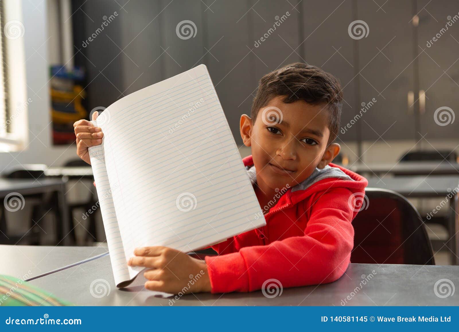 Schoolboy Showing Notebook in a Classroom Stock Image - Image of ...
