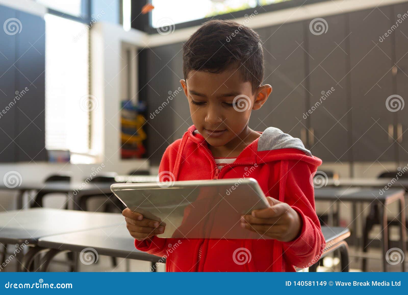 Schoolboy Using Digital Tablet at Desk in a Classroom Stock Image ...