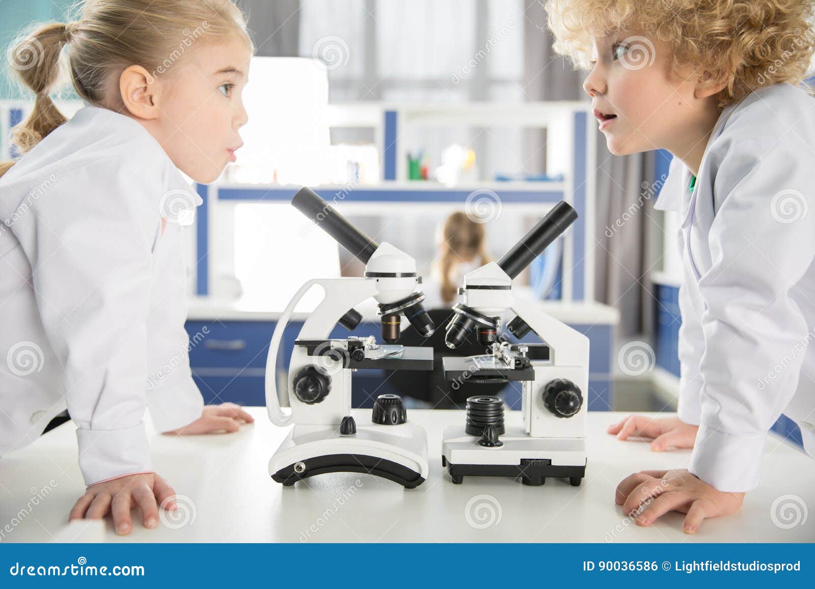Schoolchildren in Lab Coats Using Microscopes and Looking at Each Other ...