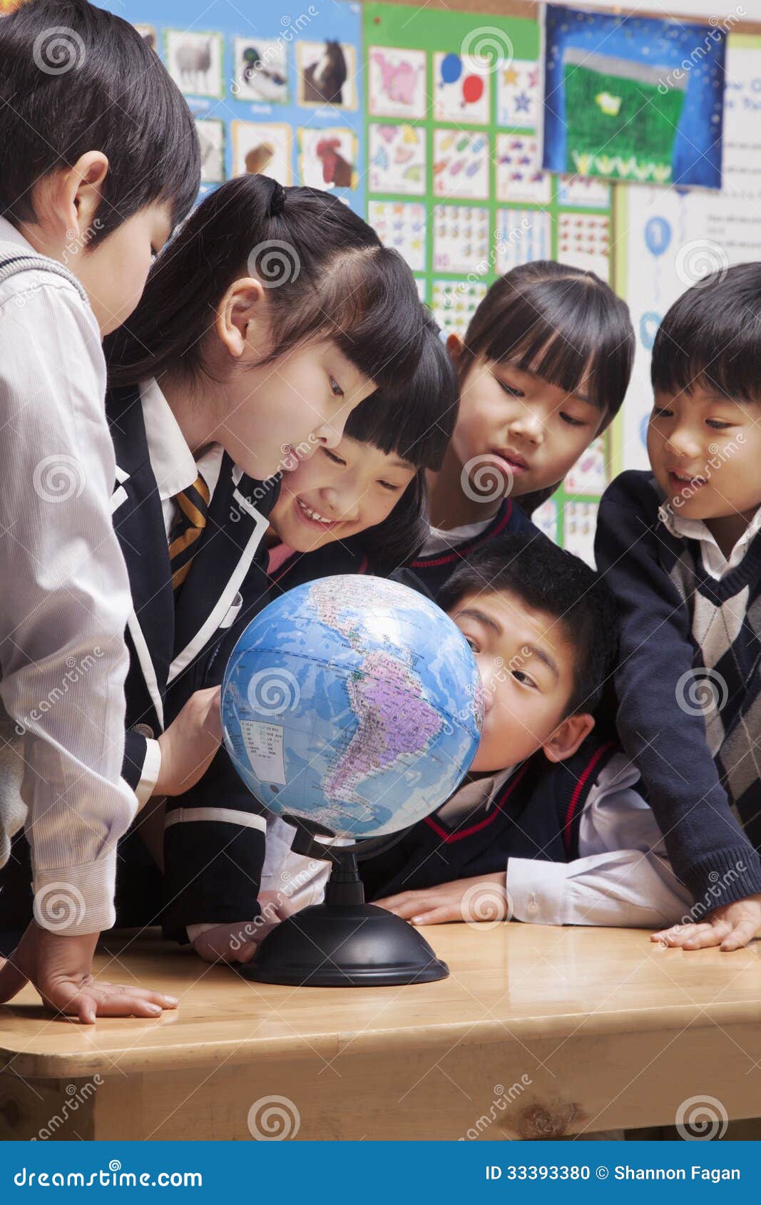 Schoolchildren Looking at a Globe in the Classroom Stock Photo - Image ... Schoolchildren Looking at a Globe in the Classroom Stock Photo - Image ...
