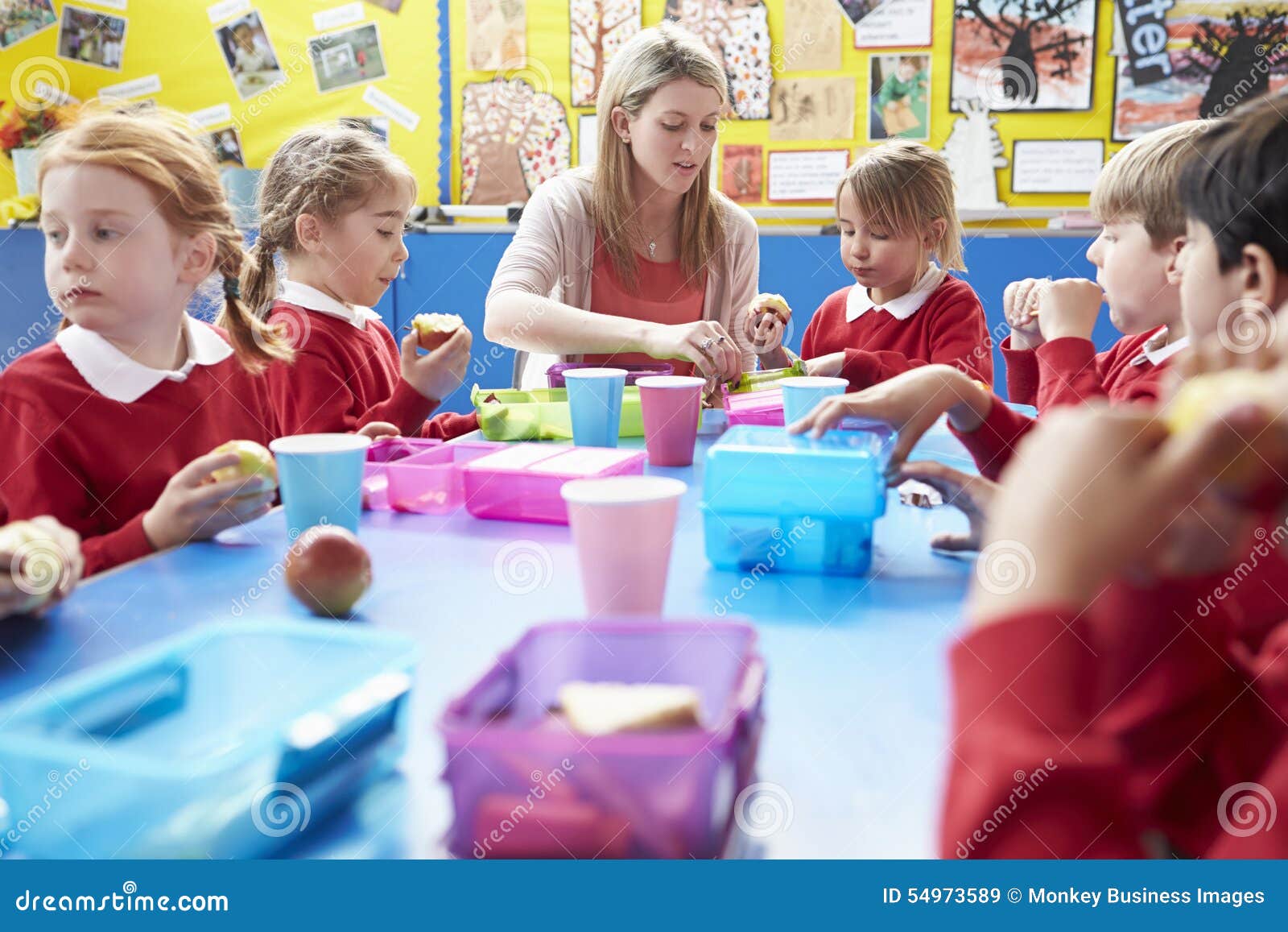 Schoolchildren with Teacher Sitting at Table Eating Lunch Stock Image ...