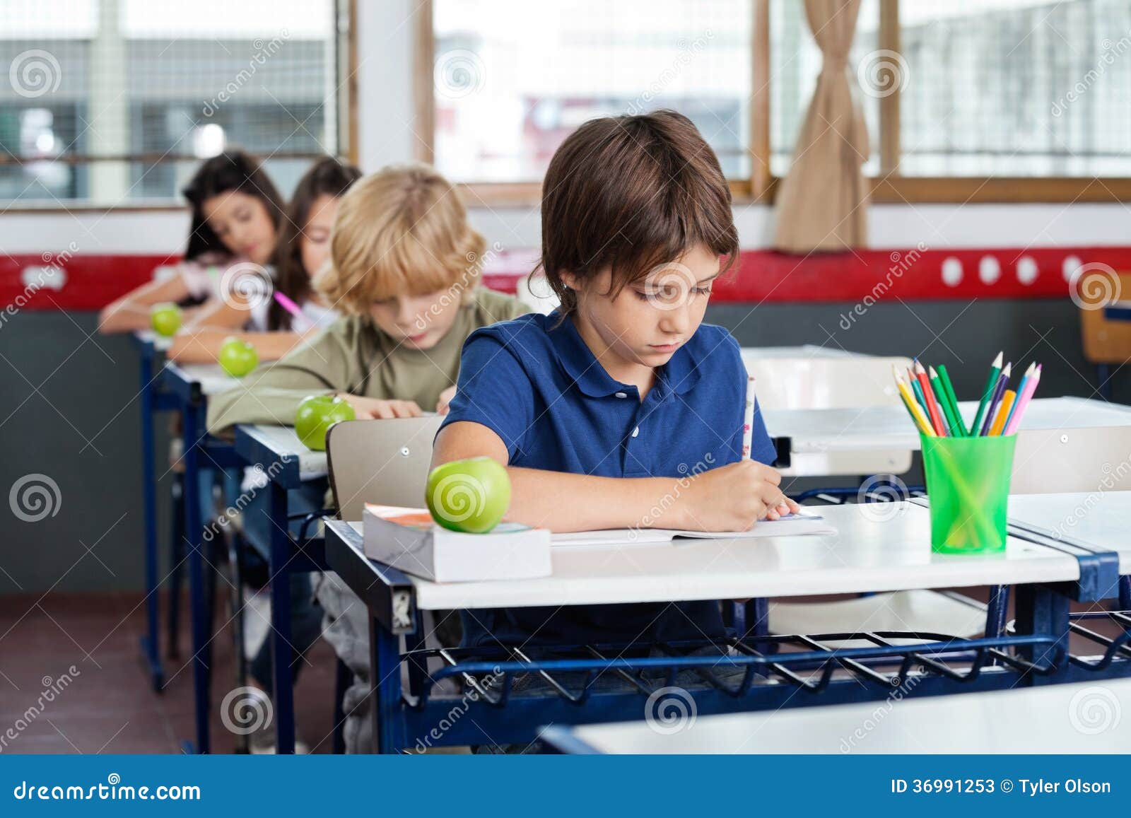 Schoolchildren Writing in Books at Desk Stock Image - Image of primary ...