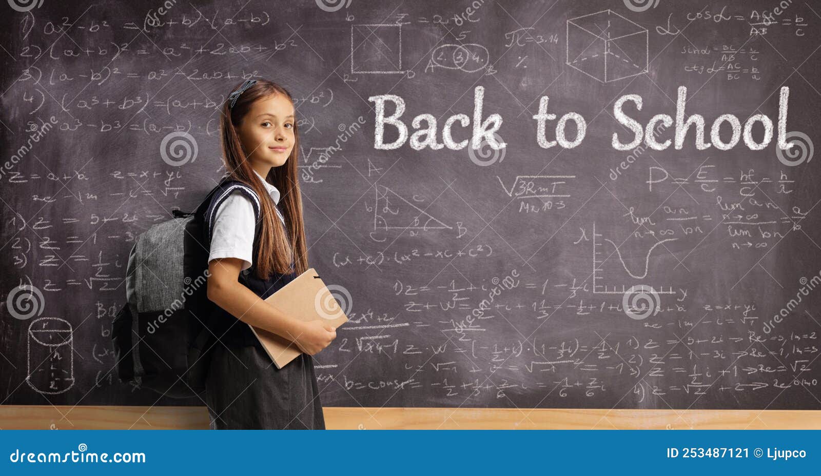 Schoolgirl with a Backpack Standing in Front of a Blackboard with ...