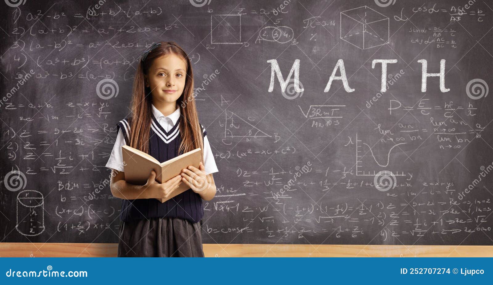 Schoolgirl with a Book Standing in Front of a Chalkboard with Math ...