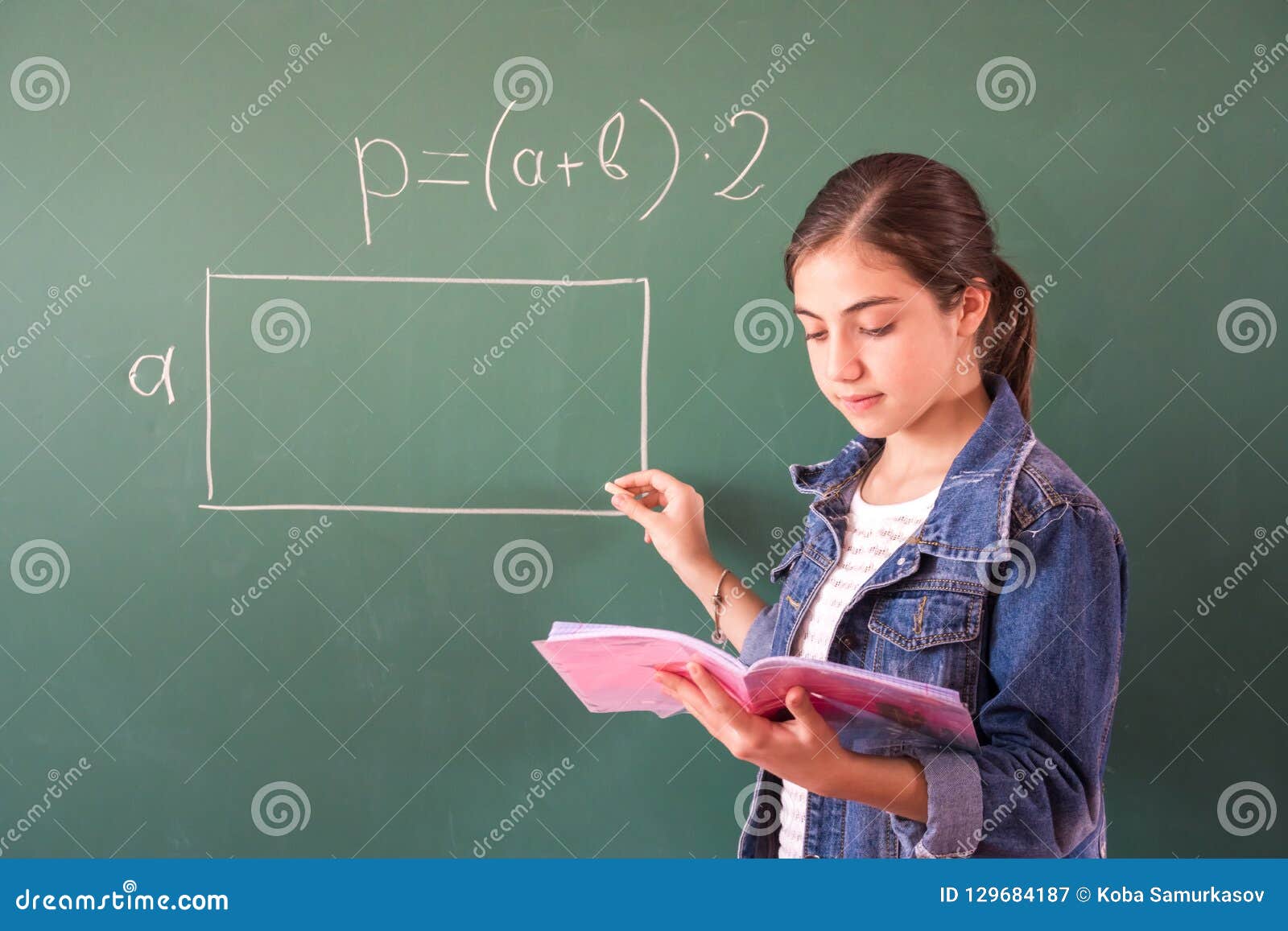 Schoolgirl With Chalk At The Blackboard Solves A Math Problem Stock ...